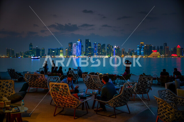 A group of people sitting in a cafe on the beach in Doha, Qatar, the ...