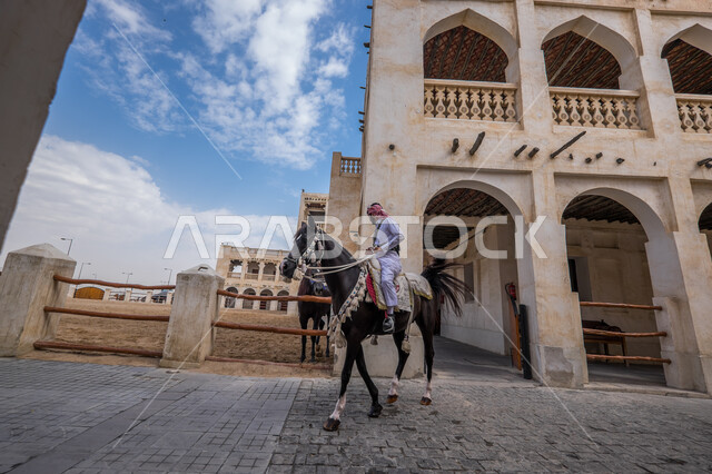 A Qatari Gulf Arab man riding an authentic Arabian horse, traditional ...