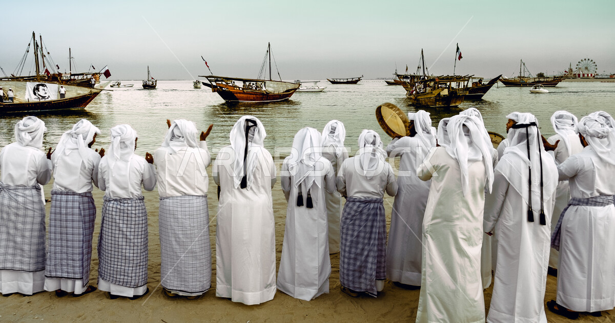 A group of Qatari Gulf Arab men on the Doha seashore in Qatar ...