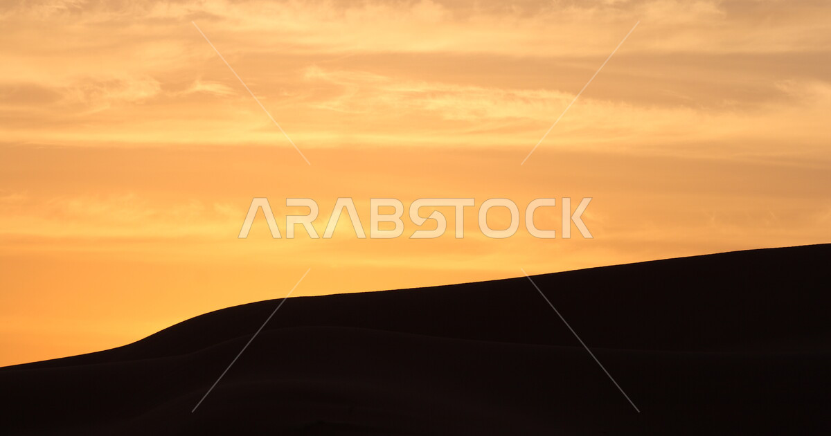 صورة ظلية لجبال في الصحراء اثناء غروب الشمس، منظر طبيعي اثناء الغروب