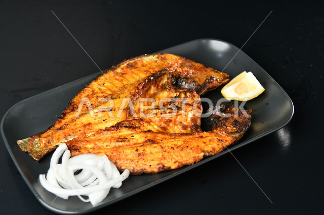 .A dish of marinated fried fish with vegetables, Arabic seafood, a ...