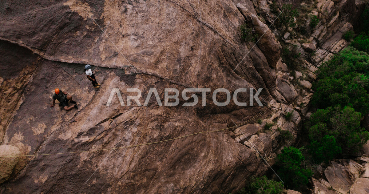 Two Saudi Arabian Gulf men climbing the Tanomah Mountains in Asir ...