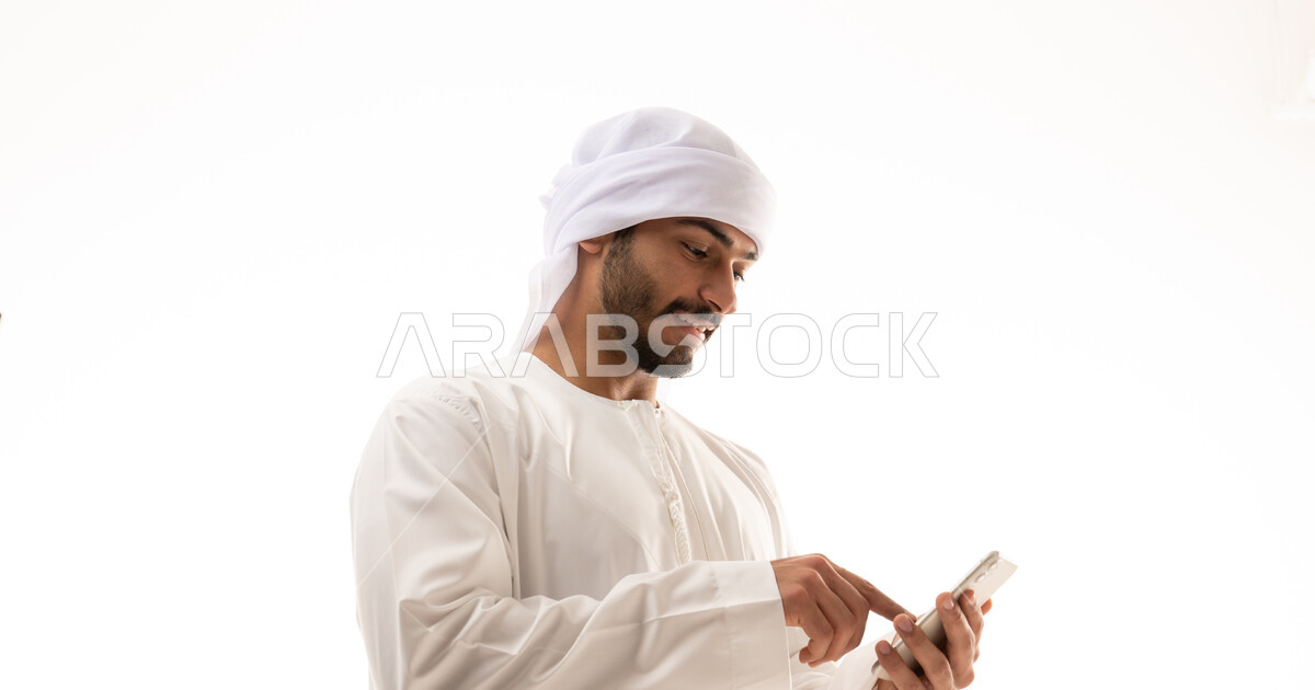 Portrait of an Arab Gulf Emirati man wearing Emirati dress, using a ...