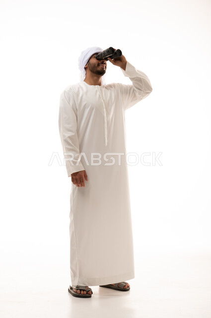 Portrait of an Arab Emirati Gulf man in traditional attire holding ...