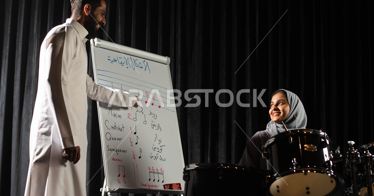 A Saudi Arabian Gulf woman on stage enjoying drumming, percussion ...
