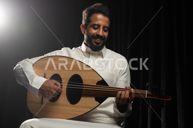 An Arab Saudi Gulf artist practicing the hobby of playing with the oud ...