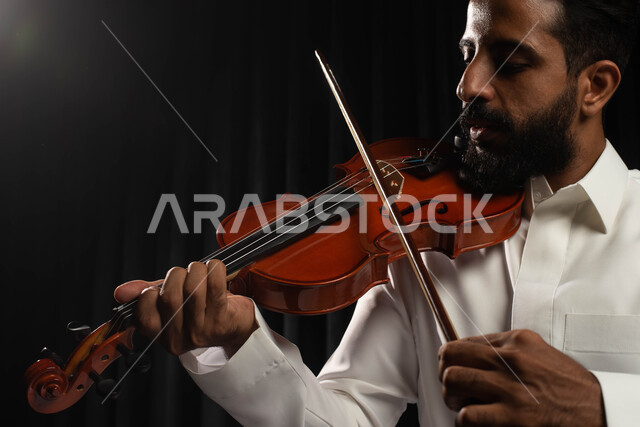 Playing the violin, musical artistic talents, a Saudi Arabian Gulf man ...