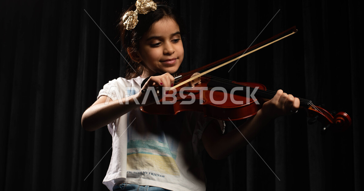 A Saudi Gulf Arab child artist who uses the stringed violin in ...