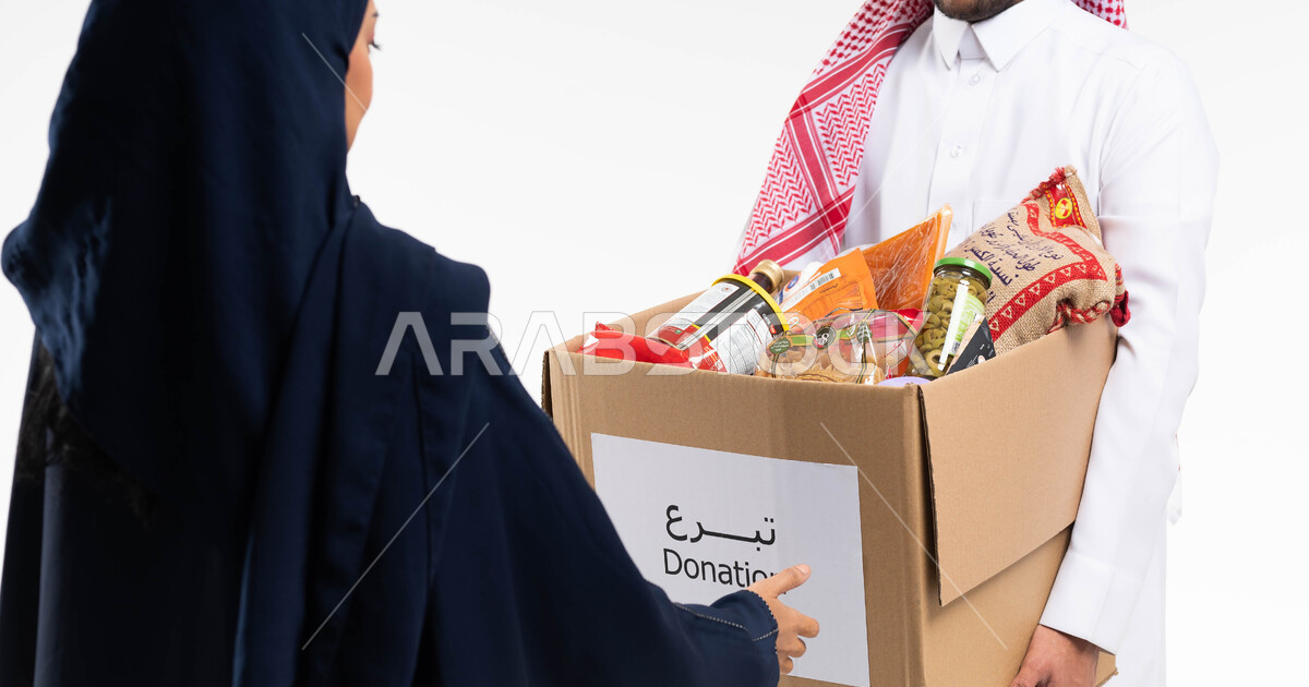 Portrait of a Saudi Arabian Gulf man giving a food basket to a needy ...