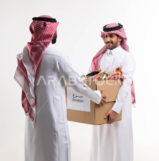 Portrait of two Saudi Arab Gulf men preparing a food box, donating to ...