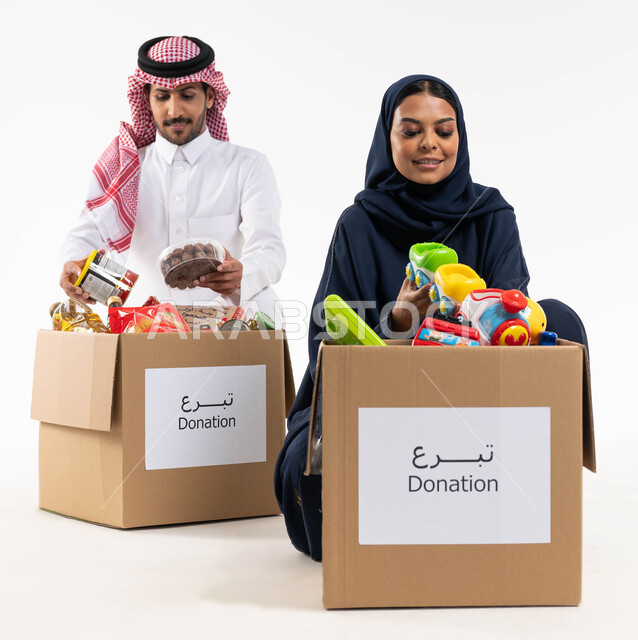 Portrait of a Saudi Gulf Arab woman and man preparing donation boxes ...