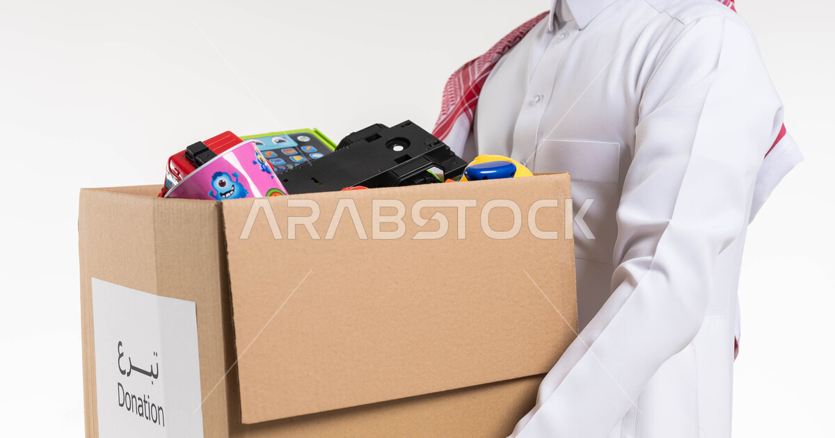 Portrait close to a Saudi Arabian Gulf man carrying a donation box full ...