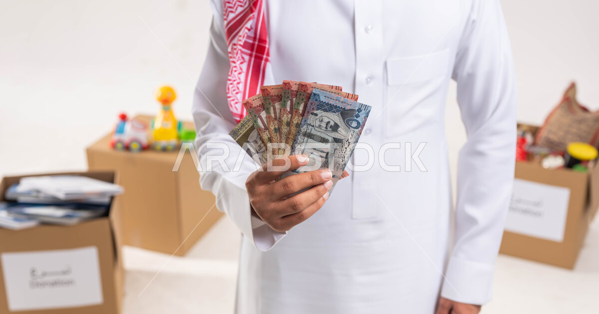 Portrait of a young Saudi Arabian Gulf man wearing traditional dress ...