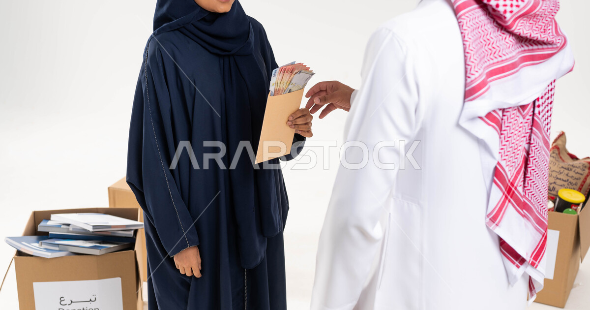 صورة مقربة لامرأة عربية خليجية سعودية تقدم المساعدة لرجل متعفف ، جمعيات ...