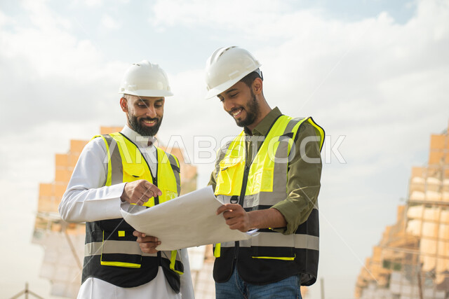 A back image of two Saudi Arab Gulf engineers supervising solar power ...