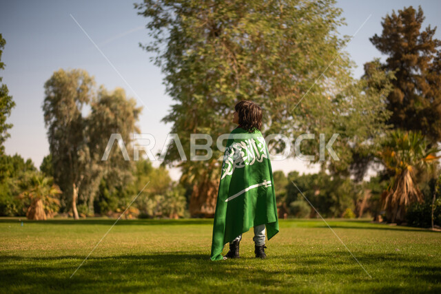 Photography from the back of a Saudi Arabian Gulf boy wearing the flag ...