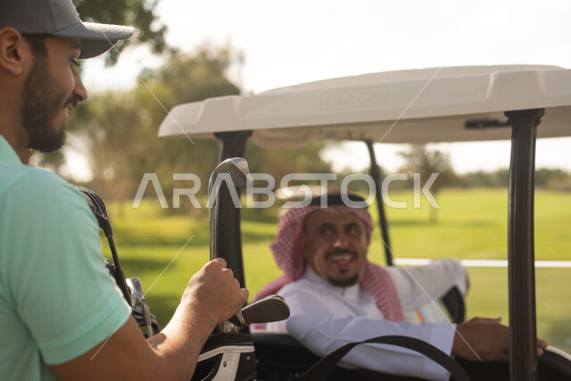 Close-up of two Saudi Arabian Gulf men on the golf course, getting ...