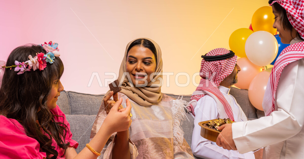 Portrait of a Saudi Arabian Gulf family celebrating Eid in the living ...