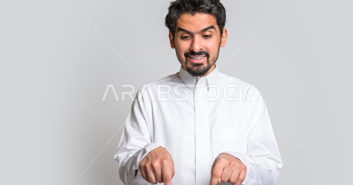 Portrait of a Saudi Arabian Gulf man wearing the Saudi thobe, pointing ...