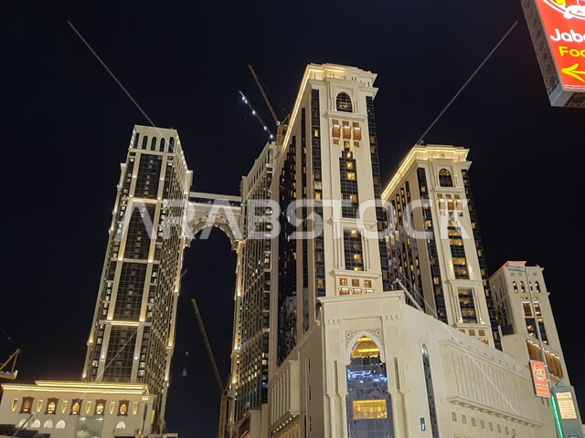 A beautiful view of pilgrims, tall buildings and lights at night on the ...