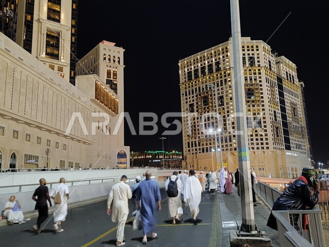 A beautiful view of pilgrims, tall buildings and lights at night on the ...