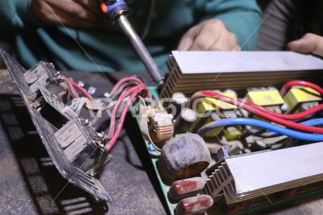 A close-up image of a man repairing electronic parts, microelectronic ...