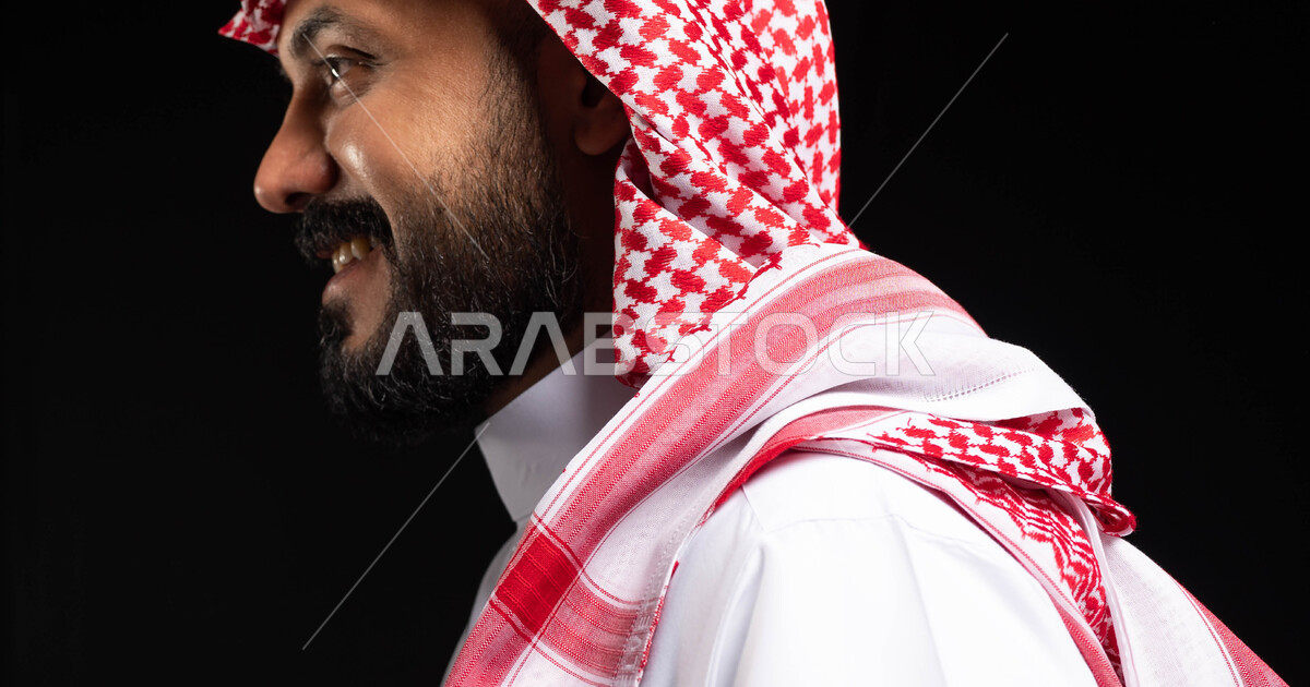 Portrait from the side of a smiling Saudi Arabian Gulf man wearing ...