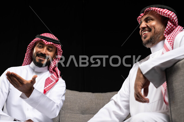 Close-up portrait of two Saudi Arabian Gulf men dressed in traditional ...