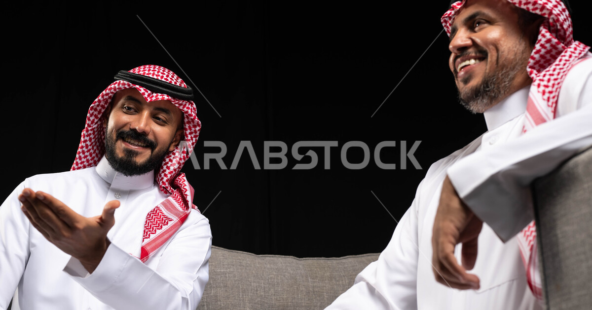 Close-up portrait of two Saudi Arabian Gulf men dressed in traditional ...