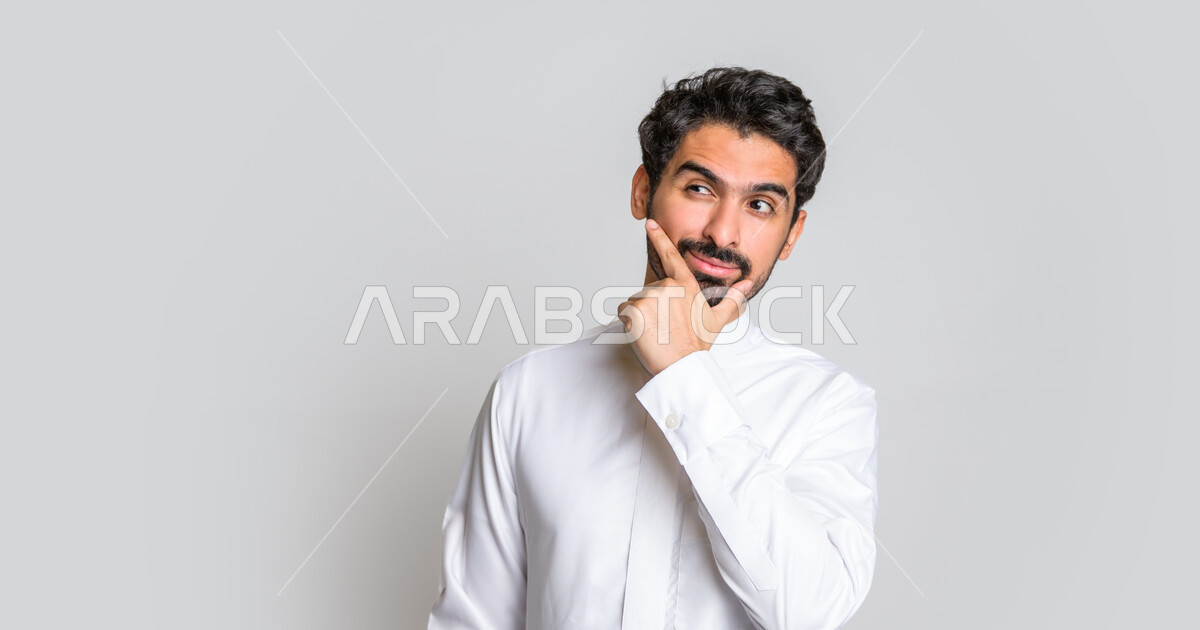 Portrait of a Saudi Gulf man in traditional dress, making facial and ...