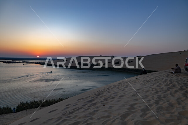 Two Saudi Arabian Gulf men sitting on the shore of Lake Asfar in Al ...