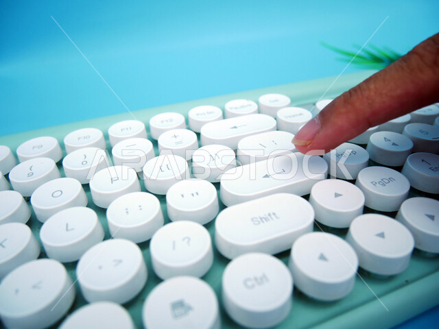 Close-up of a man's finger clicking on keyboard buttons, white keyboard ...