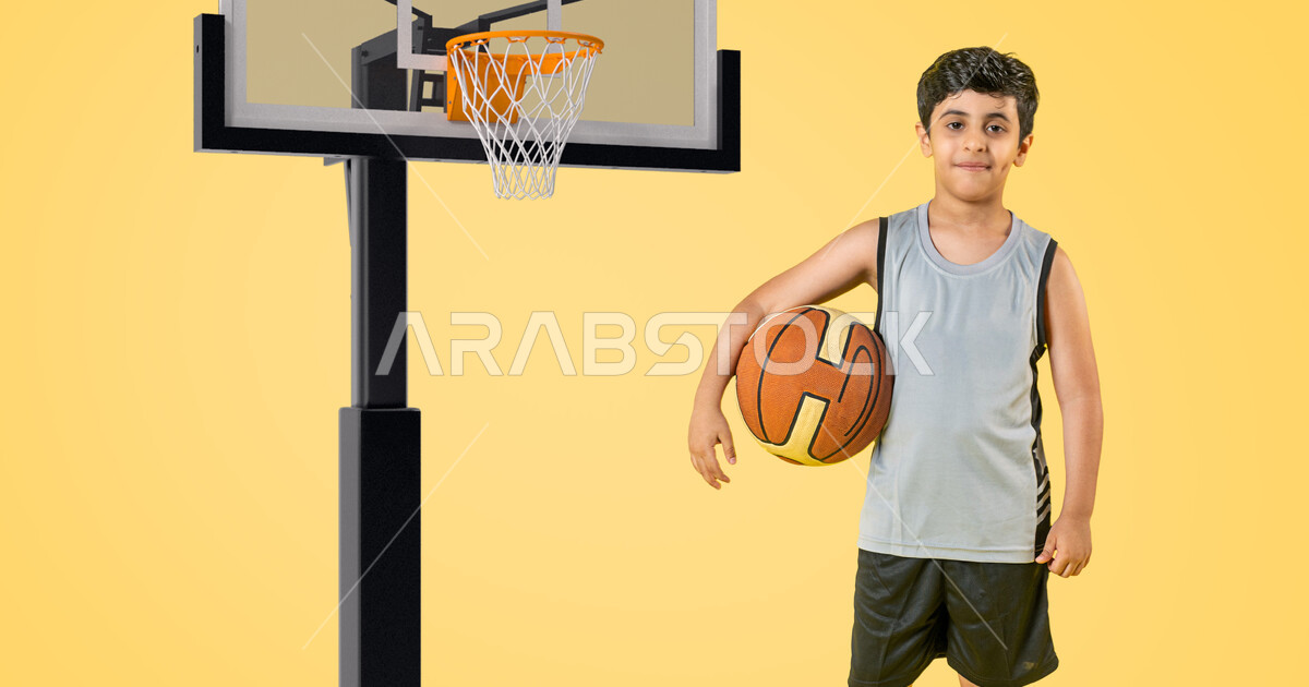 Portrait of a Saudi Arab Gulf boy holding a basketball and wearing ...