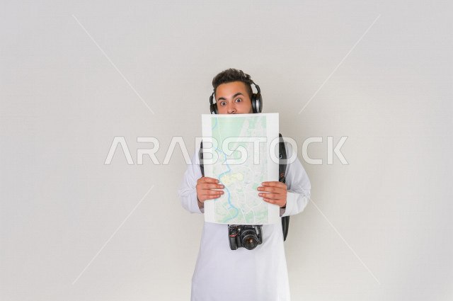 Portrait of a Saudi Arabian Gulf youth wearing a backpack, headphones ...
