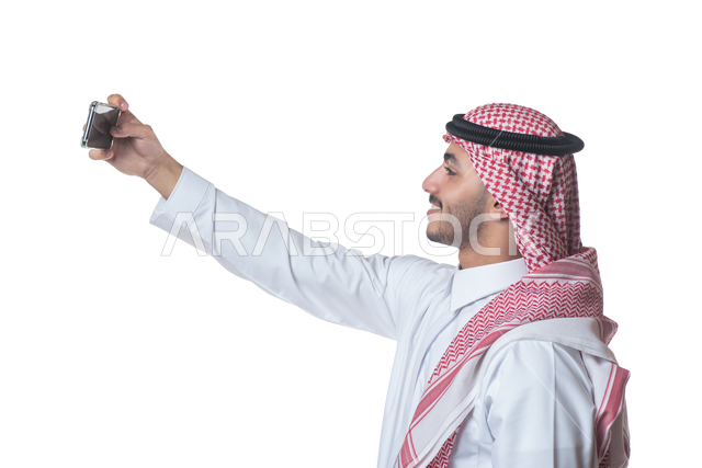 An angled picture of a Saudi Arabian Gulf youth holding a mobile phone ...