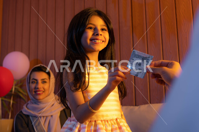 Presenting Eidiya to children, a Saudi Arabian Gulf girl celebrating ...