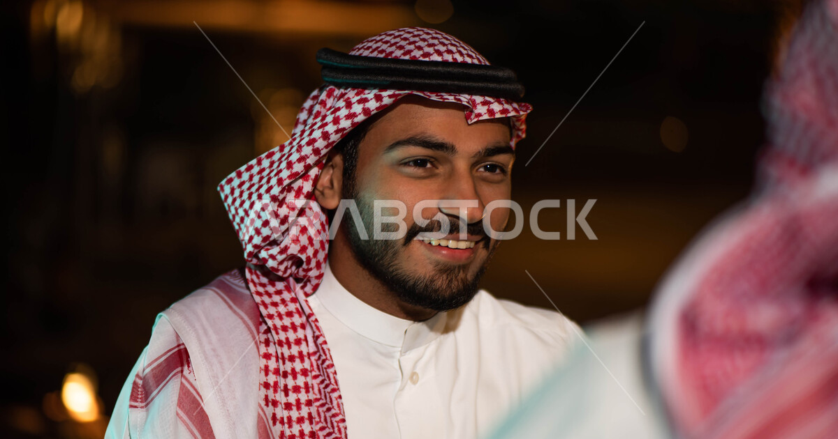 A picnic in the open air, two Saudi Arabian Gulf men dressed in ...