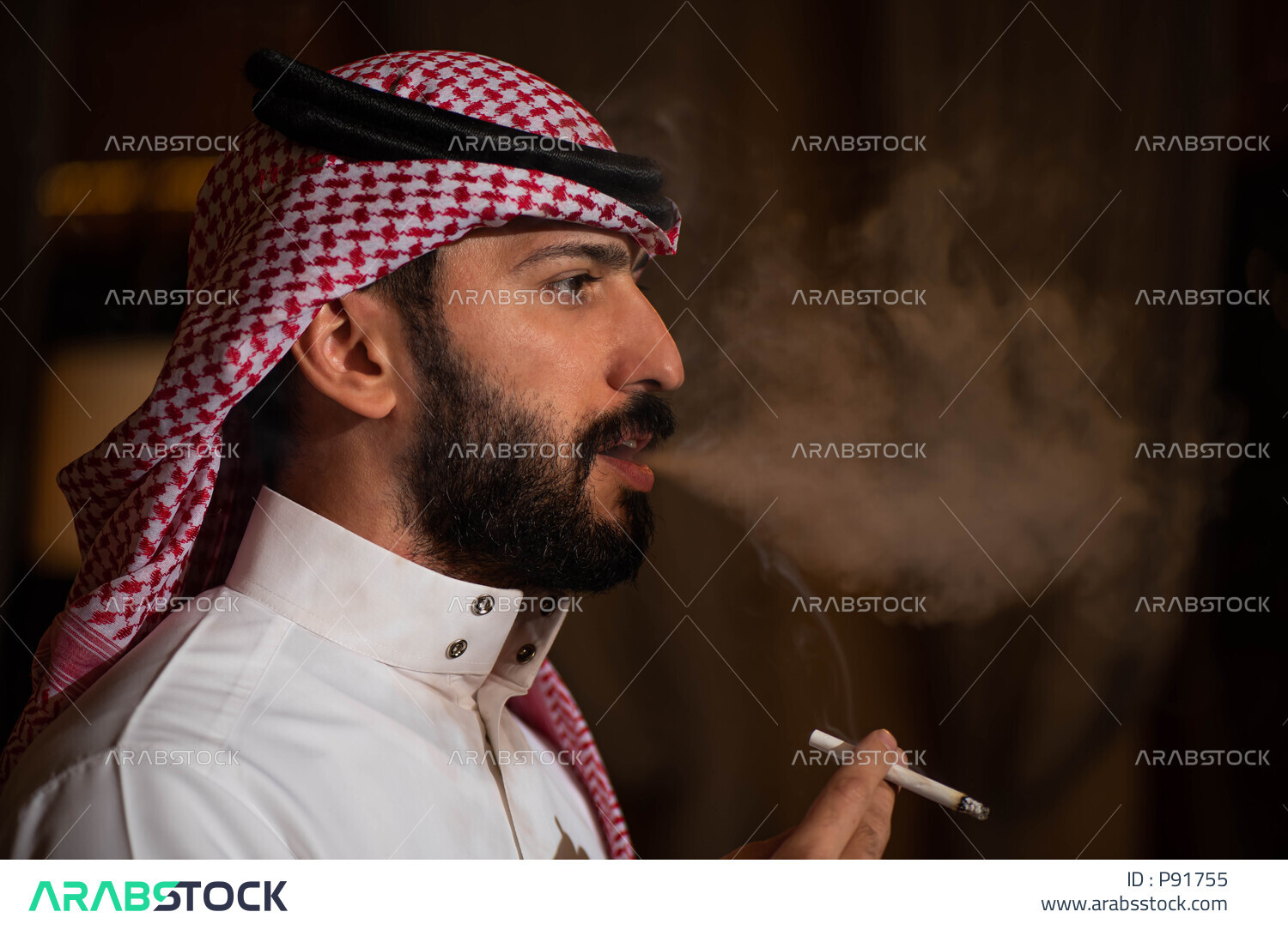 A close-up of a Saudi Arabian Gulf man wearing a Saudi dress smoking ...