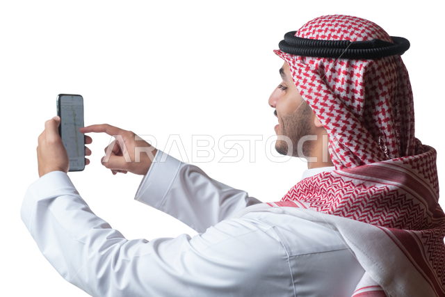 An angled image of a Saudi Arabian Gulf youth holding a mobile phone ...