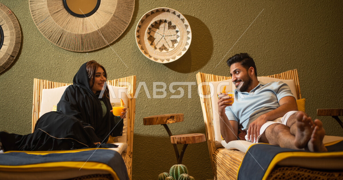 الاستمتاع بشرب العصير الطازج وعطلة صيفية ، زوجان عربيان خليجيان سعوديان