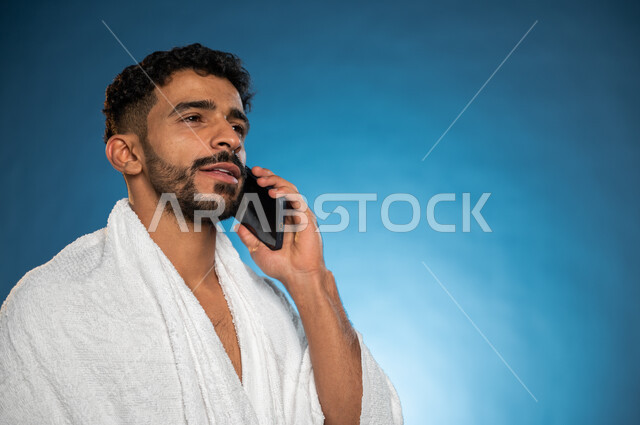 Using a mobile phone, a portrait of a Saudi Arabian Gulf Muslim man ...