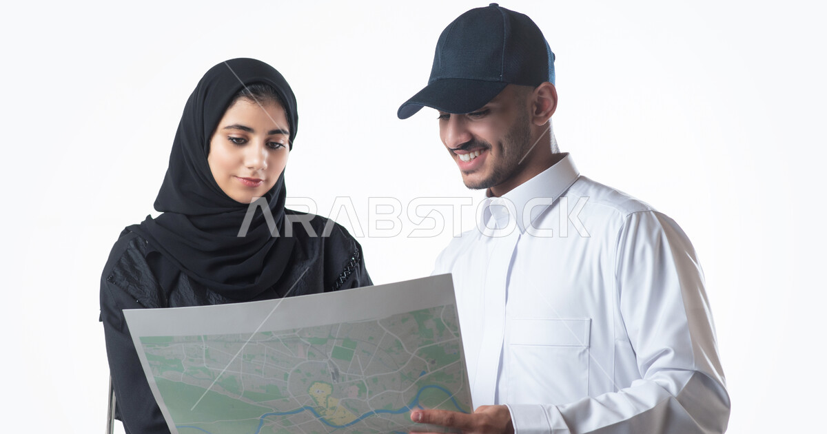Portrait of a Gulf Arab couple, tourists, holding a travel map with ...