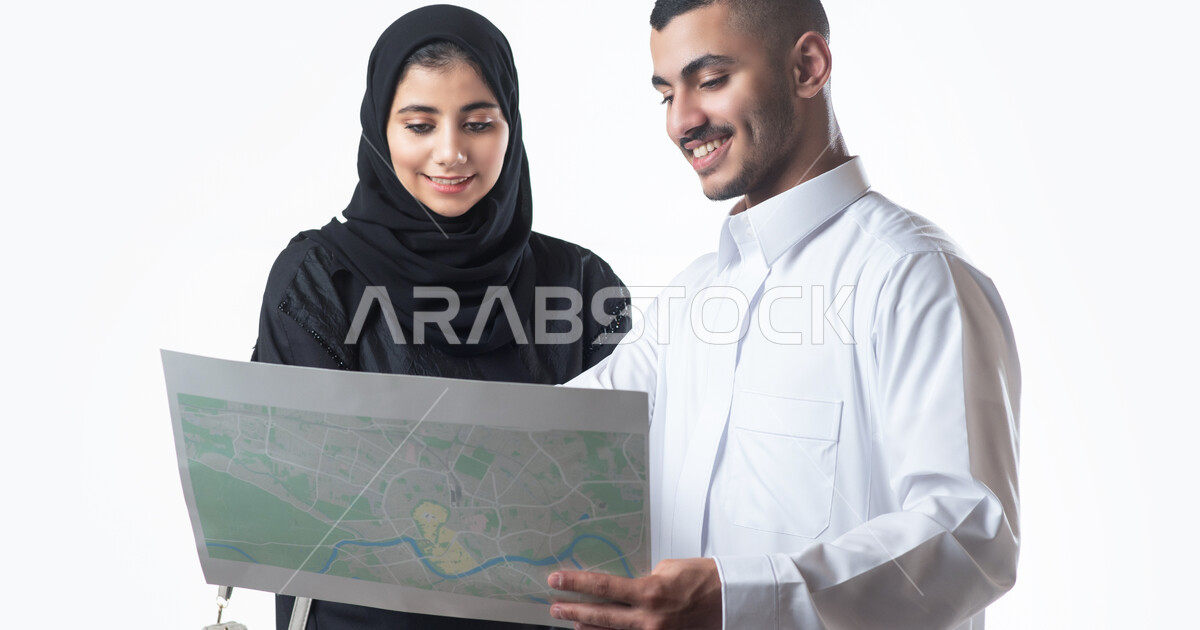Portrait of a Gulf Arab couple, tourists, holding a travel map with ...