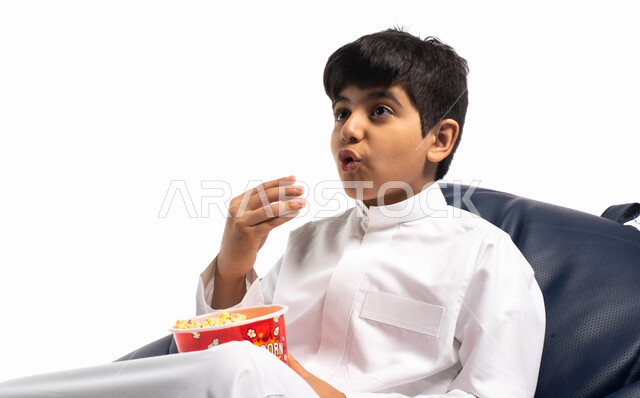 Enjoying eating popcorn, a portrait of a Saudi Arabian Gulf child ...