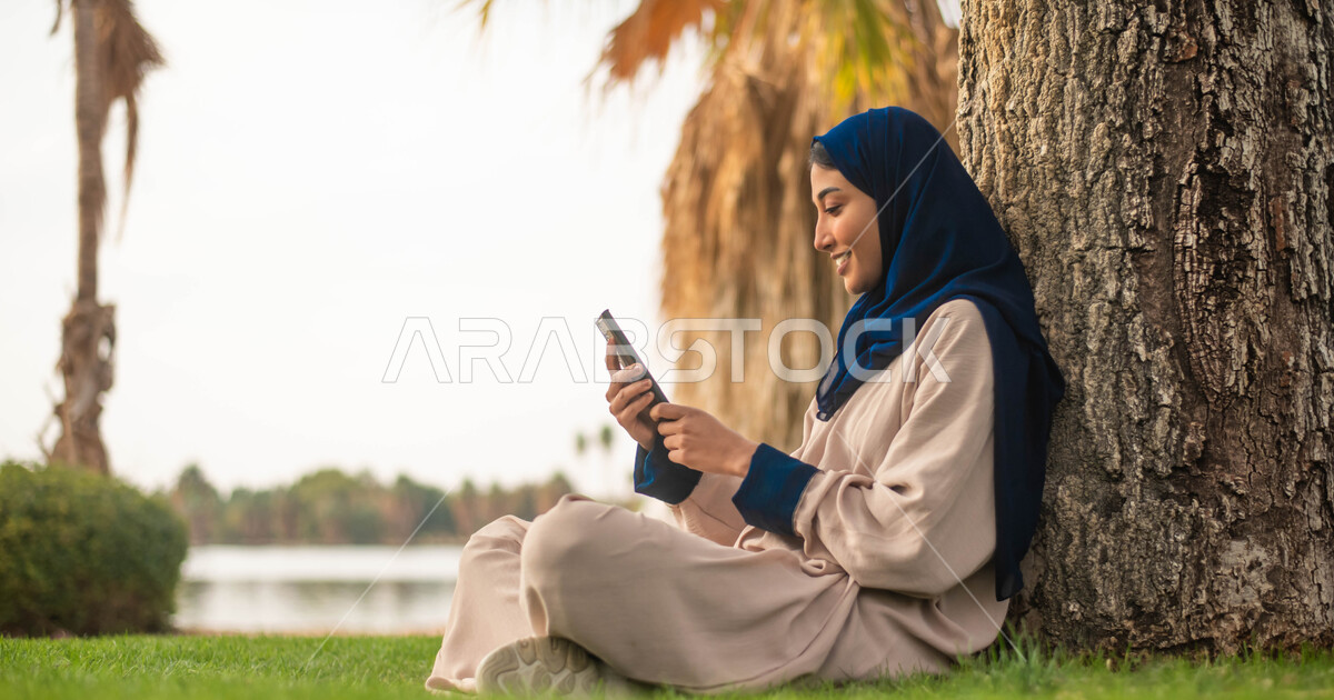 Surfing the Internet and social media, a Saudi Arab Gulf woman sitting ...
