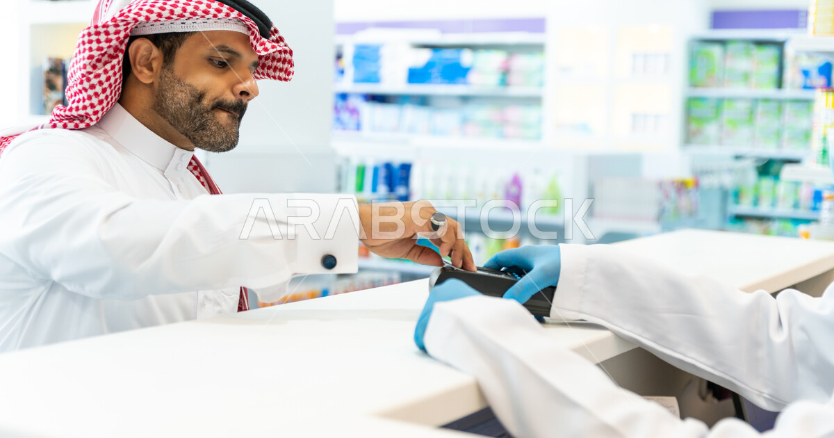 A Saudi Arabian Gulf man inside the pharmacy, he pays for medicines ...