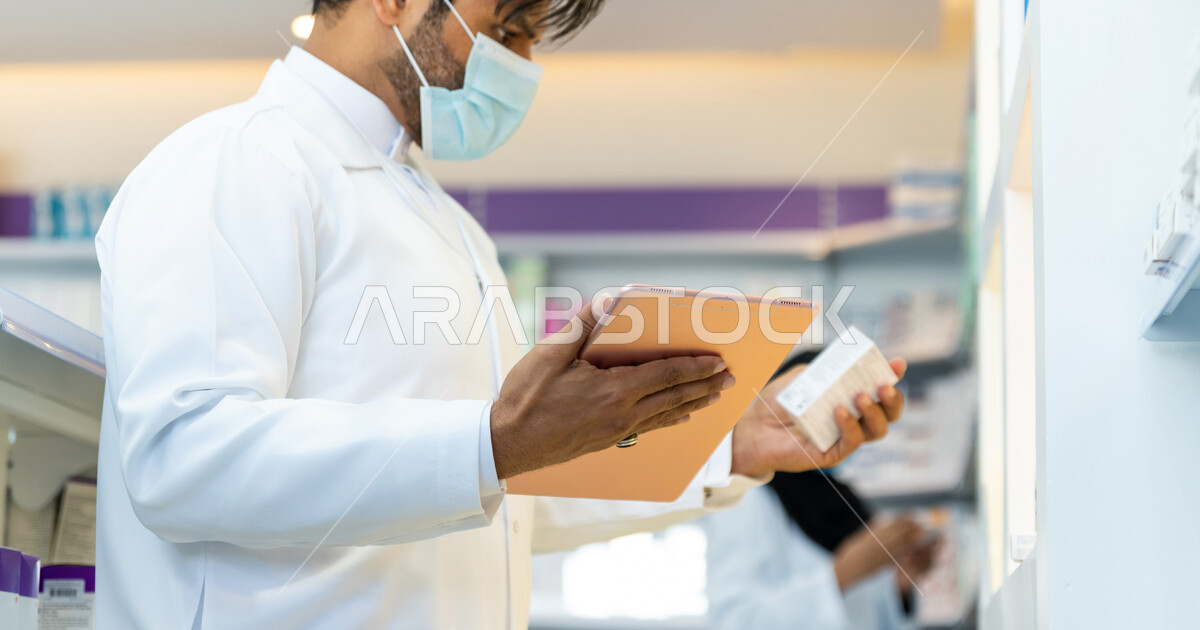 A Saudi Arabian Gulf pharmacist wearing a mask to prevent corona virus ...
