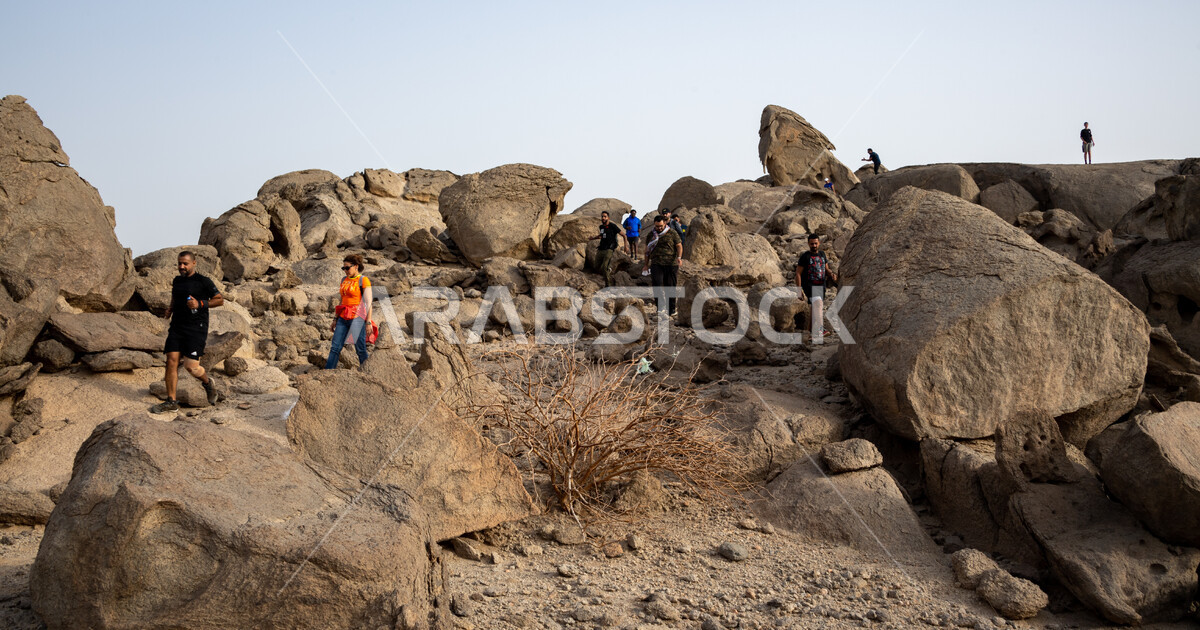 Mountain stones and rocks, a group of Saudi Gulf Arab youth climbing ...