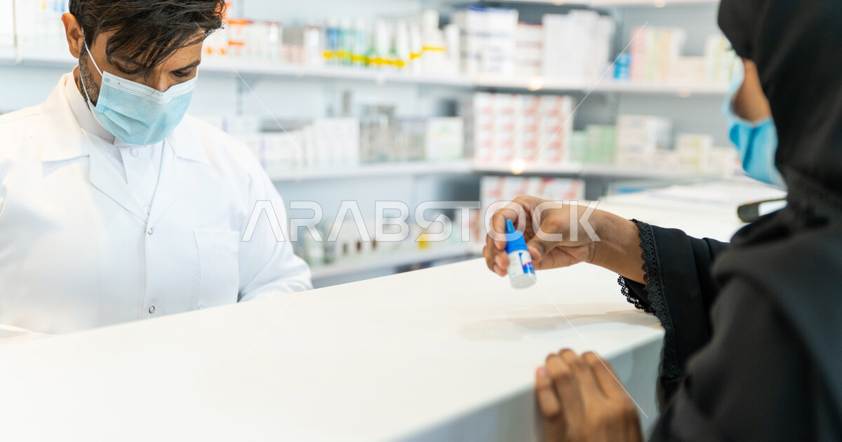 A Saudi Arabian Gulf woman presenting the medical prescription to a ...