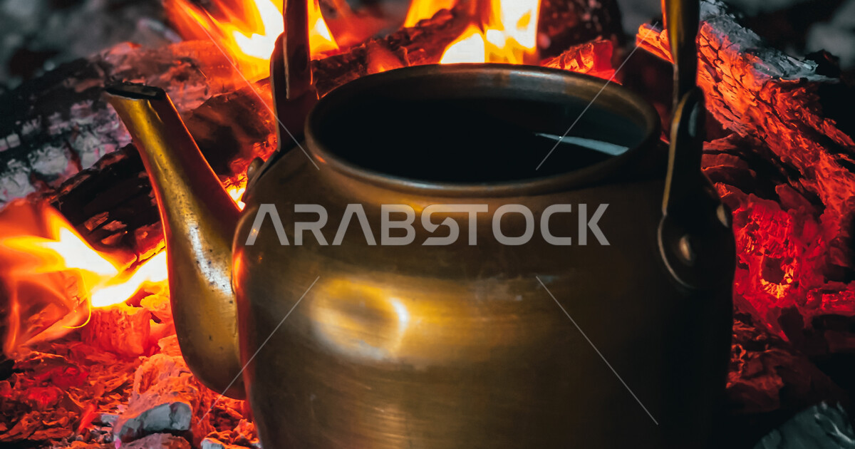 A close-up of a golden jug on charcoal, a popular Arab prayer session ...